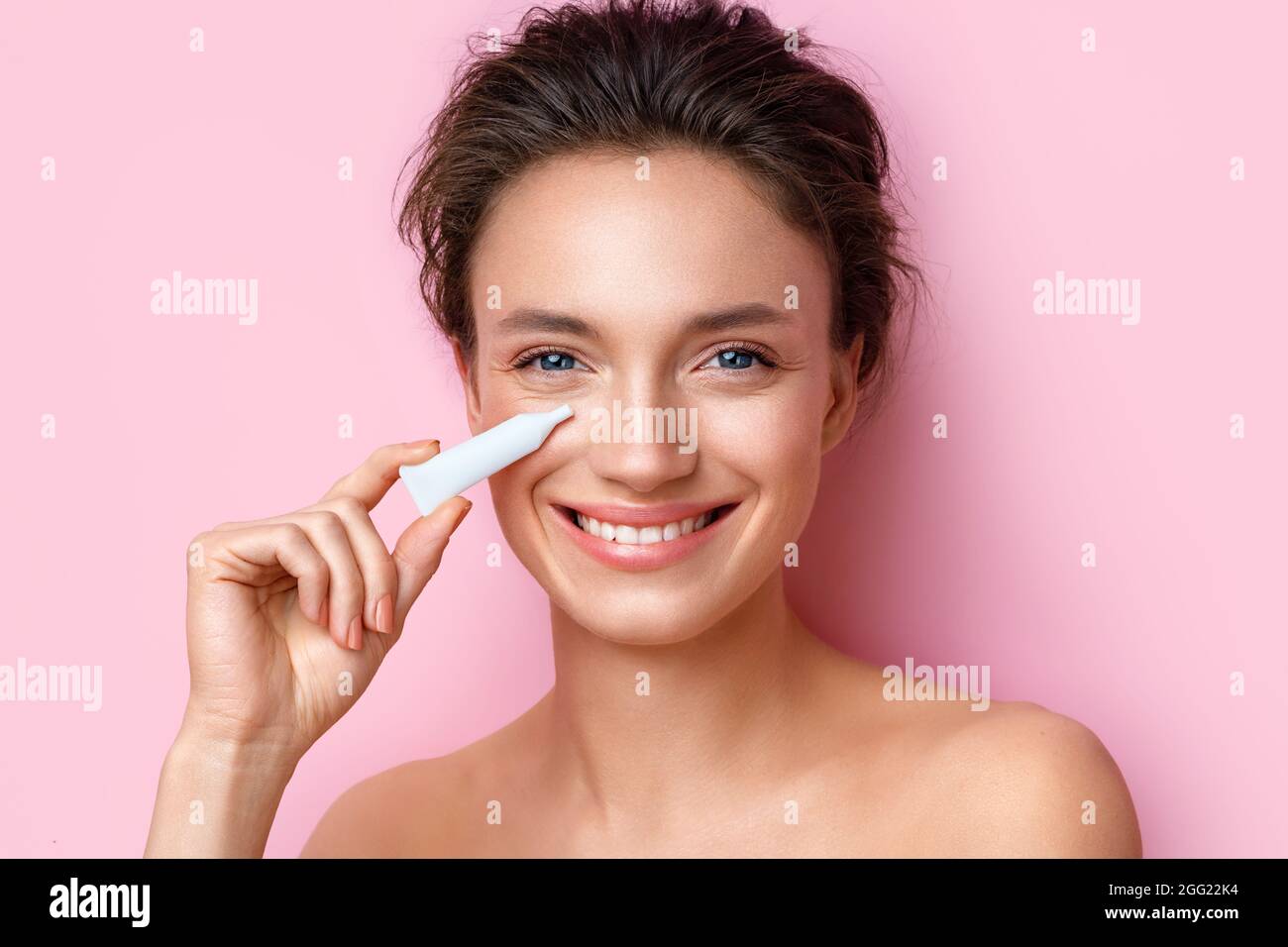 Beautiful woman using cream around the eyes. Photo of woman with ...
