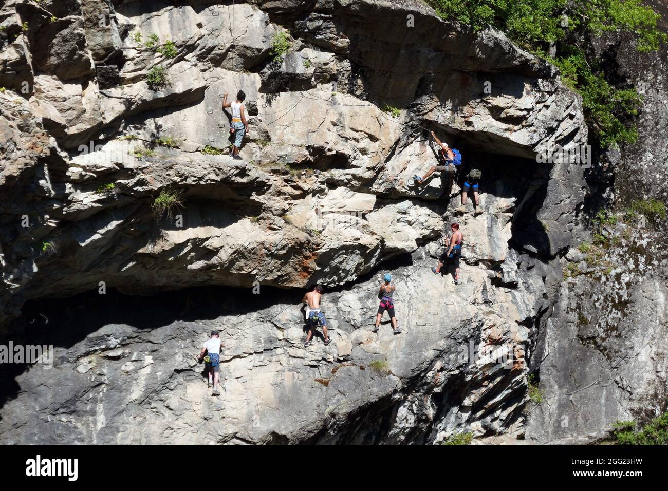 Queue of climbers on Via Ferrata in summer in the remote valley of ...