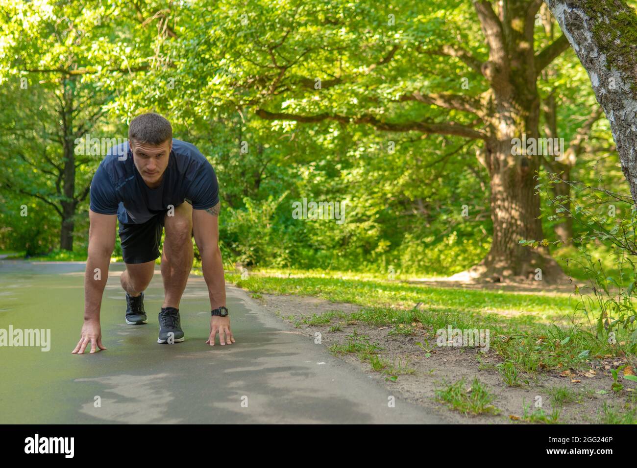 A man athlete runs in the park outdoors, around the forest, oak trees ...