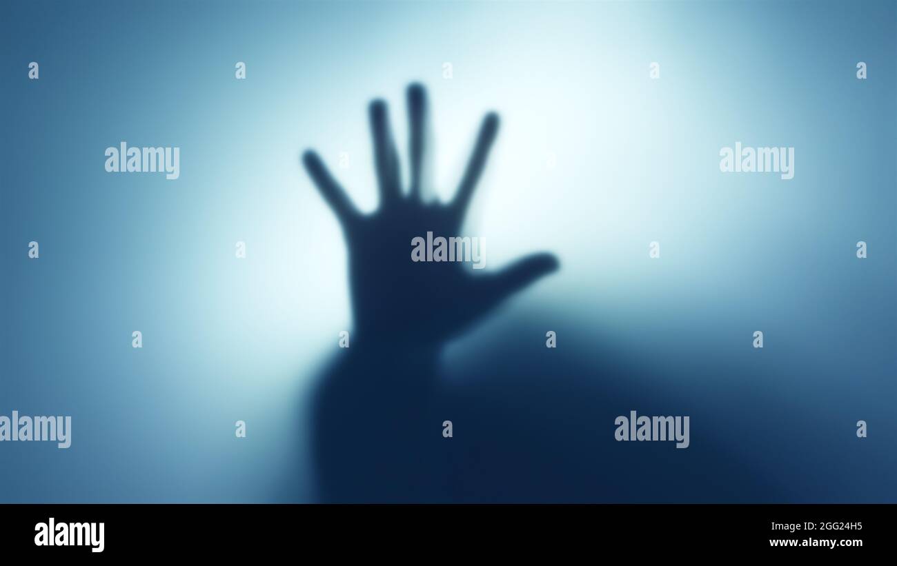 Silhouette of a man's hand behind a translucent glass. The concept of ...