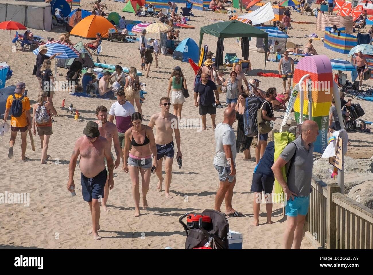 Holidaymakers on a very busy and crowded Fistral Beach in the intense ...