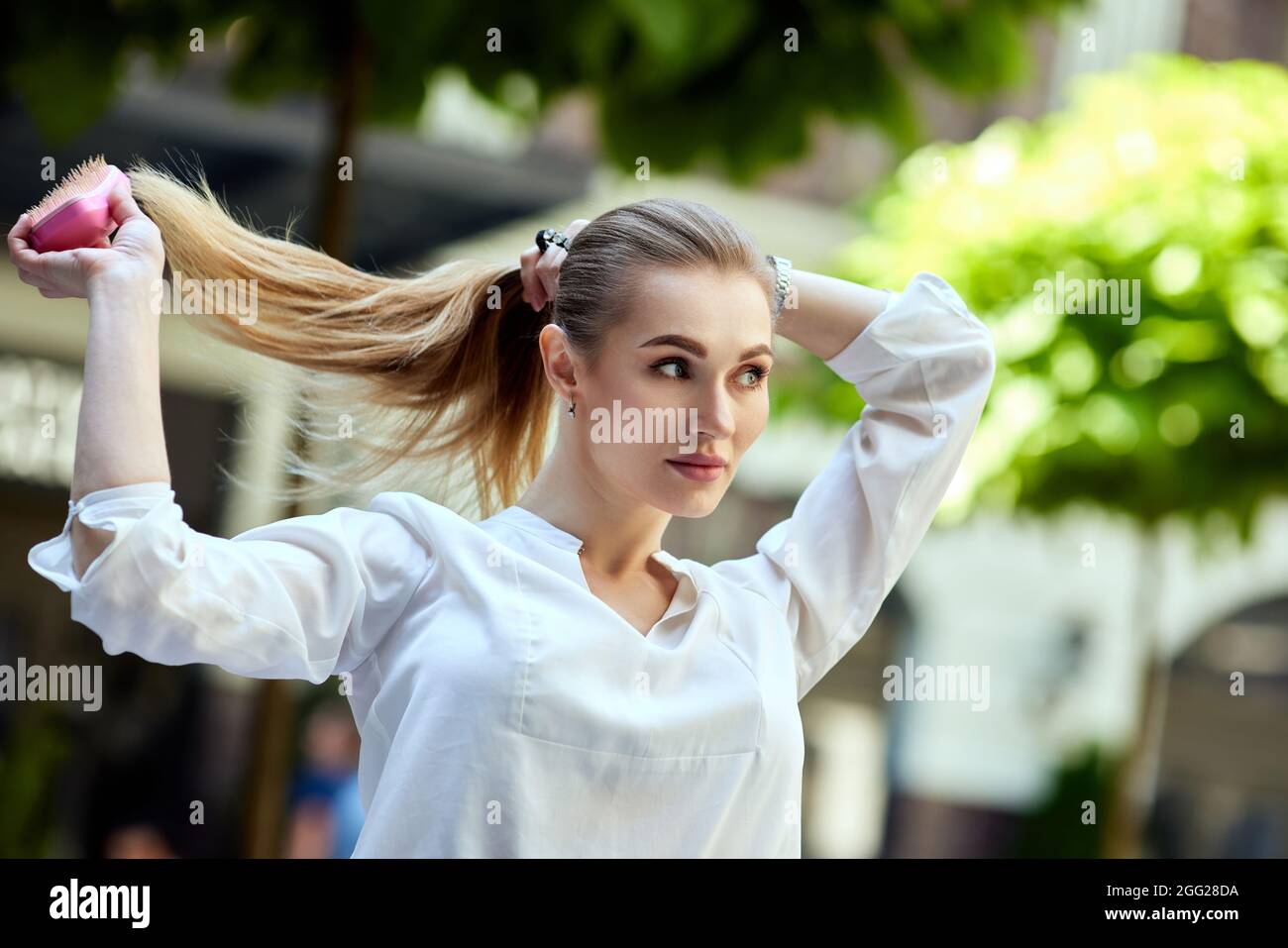 beautiful woman combs long hair with brush Stock Photo - Alamy