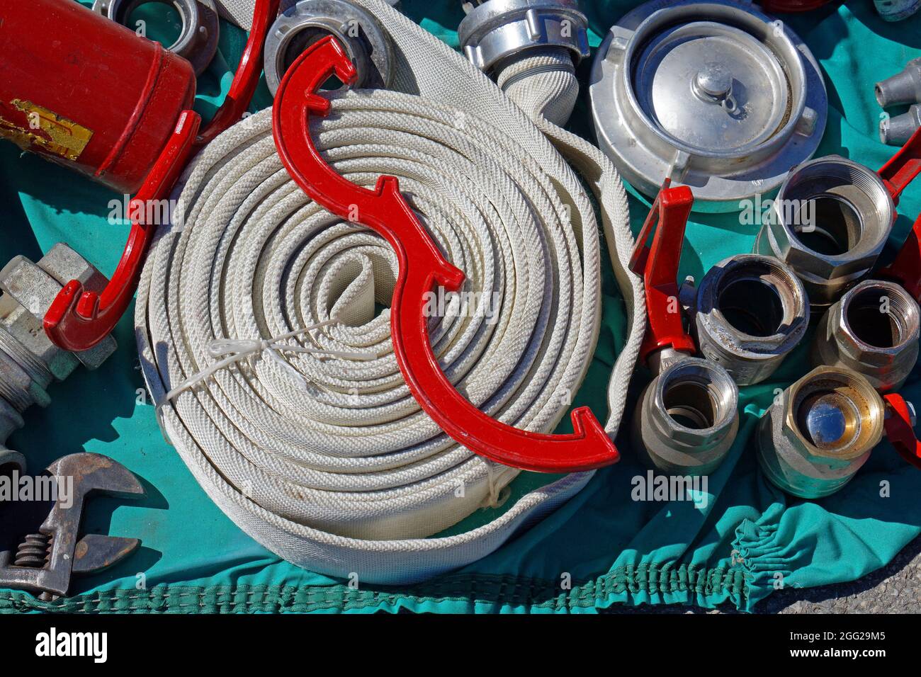 Rolled up fire hose on floor ready to be used Stock Photo - Alamy