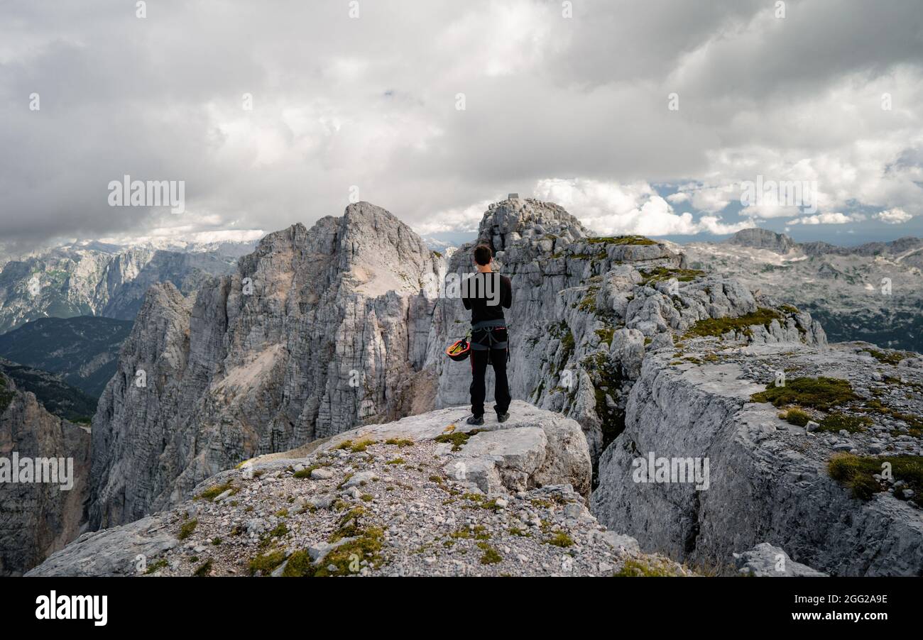 An alpinist climbing an mountain ridge. Climber ascent. Scenic ...
