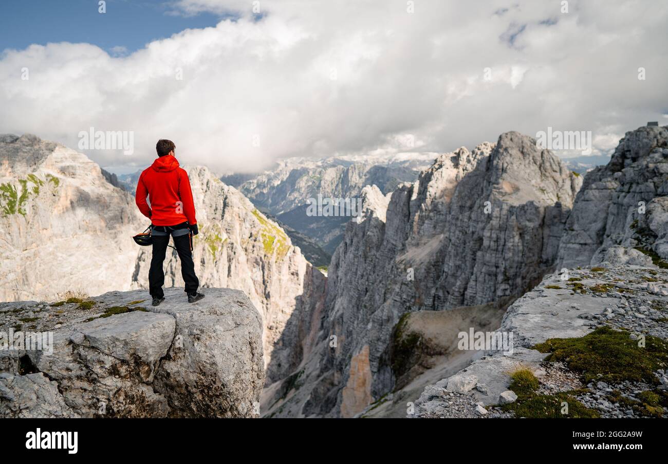 An alpinist climbing an mountain ridge. Climber ascent. Scenic ...