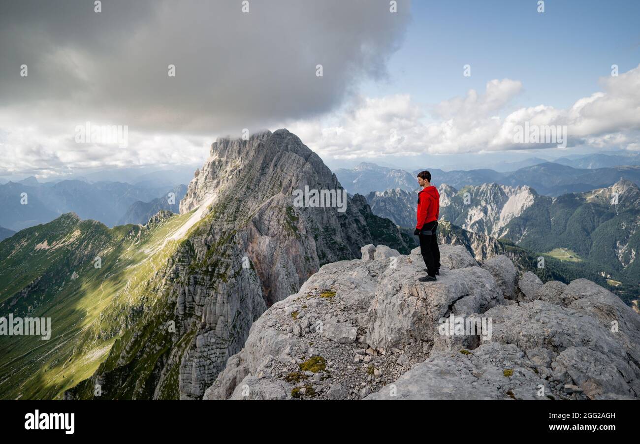 An alpinist climbing an mountain ridge. Climber ascent. Scenic ...