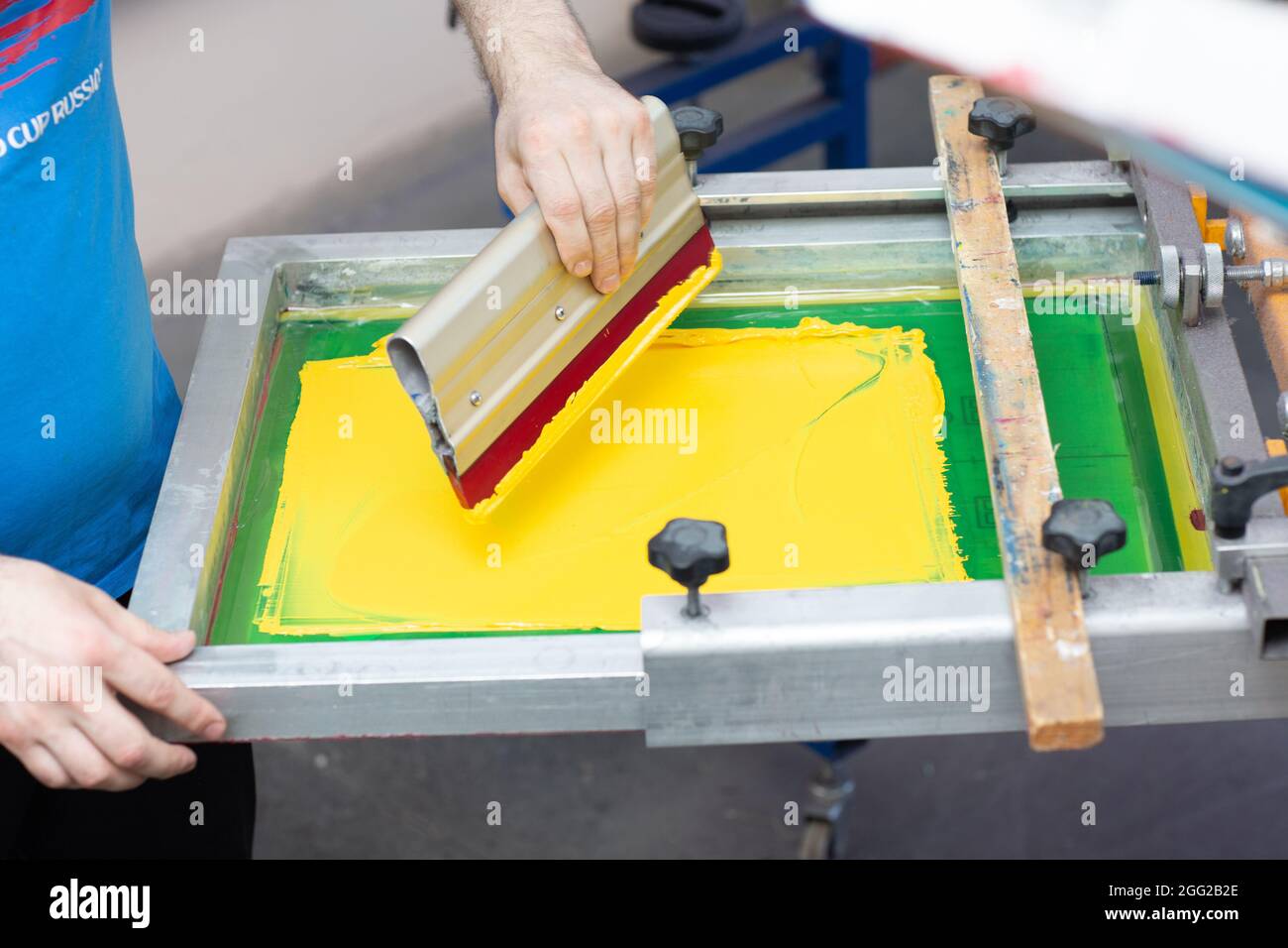 Serigraphy silk screen print process at clothes factory. Frame ...