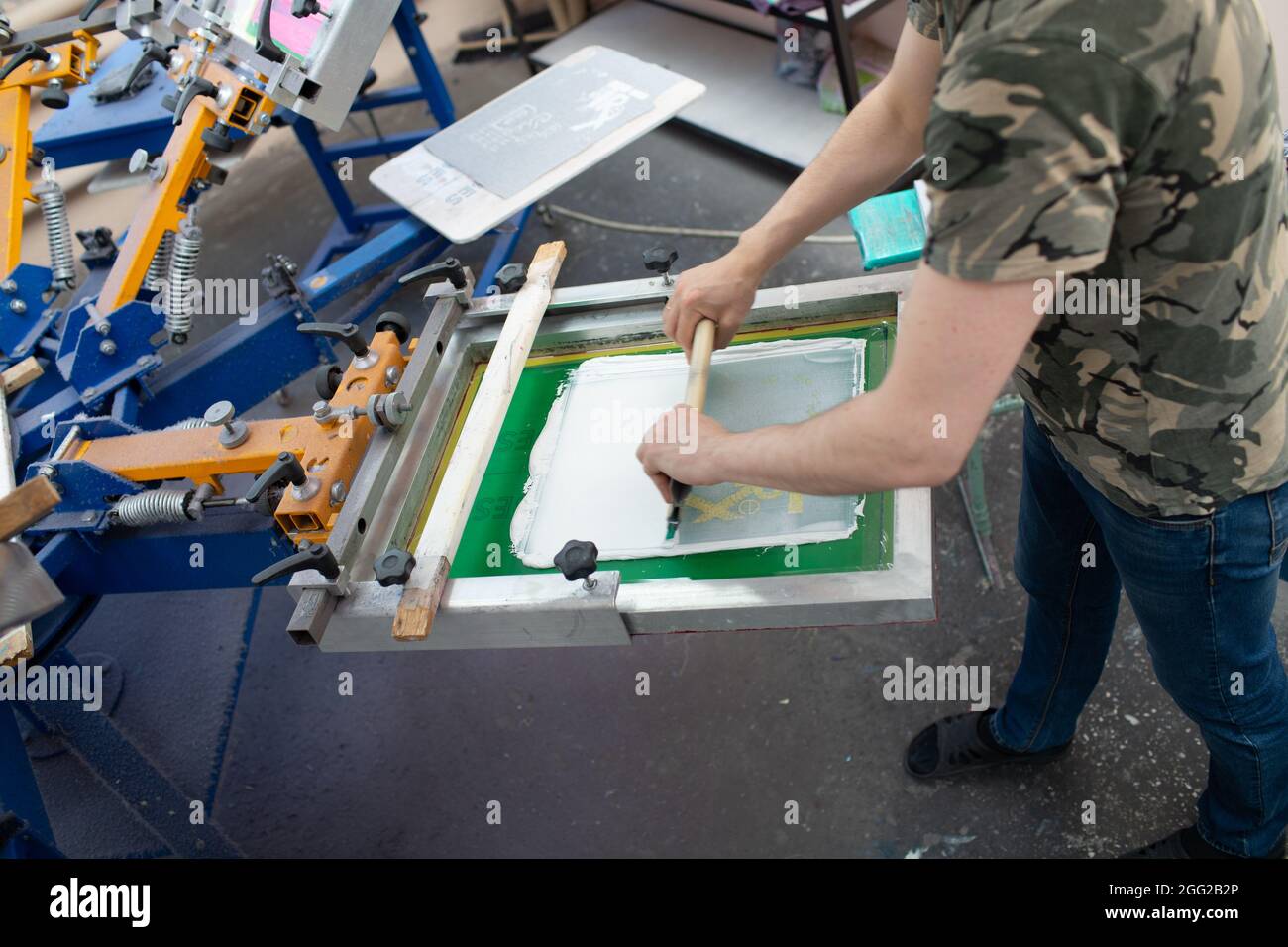 Serigraphy silk screen print process at clothes factory. Frame ...