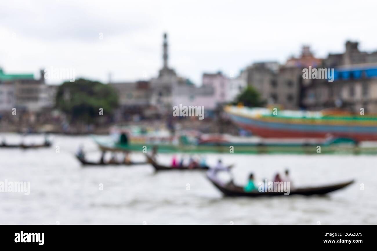 Blurry defocused image of a busy river with passing wooden boats and ...