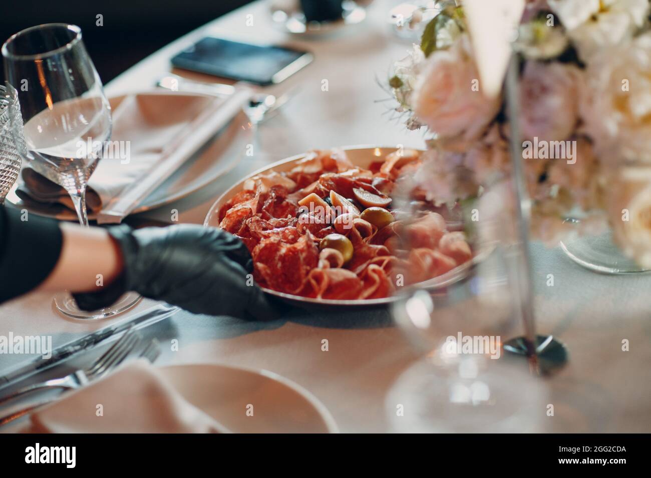 Various cold cuts on a plate waiter catering holds Stock Photo - Alamy