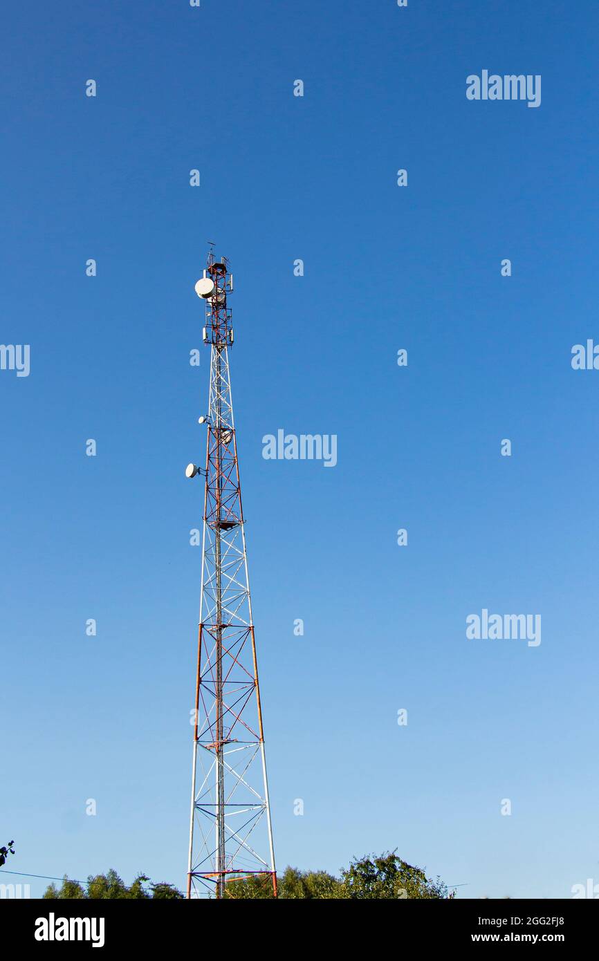 Telecommunications tower and satellite dish telecom network on blue sky ...