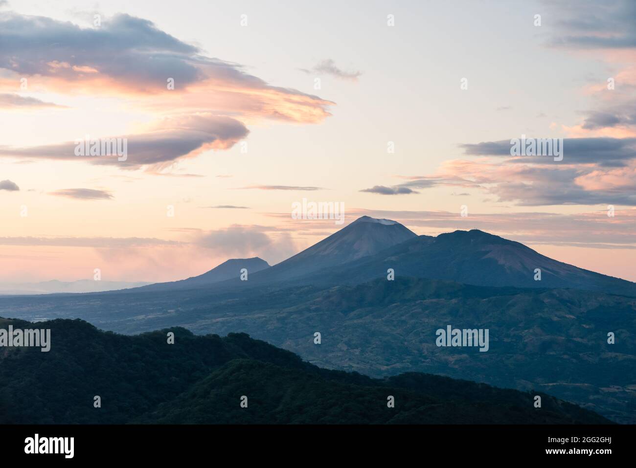 Aerial landscape view of green mountains and volcanoes at sunset with ...