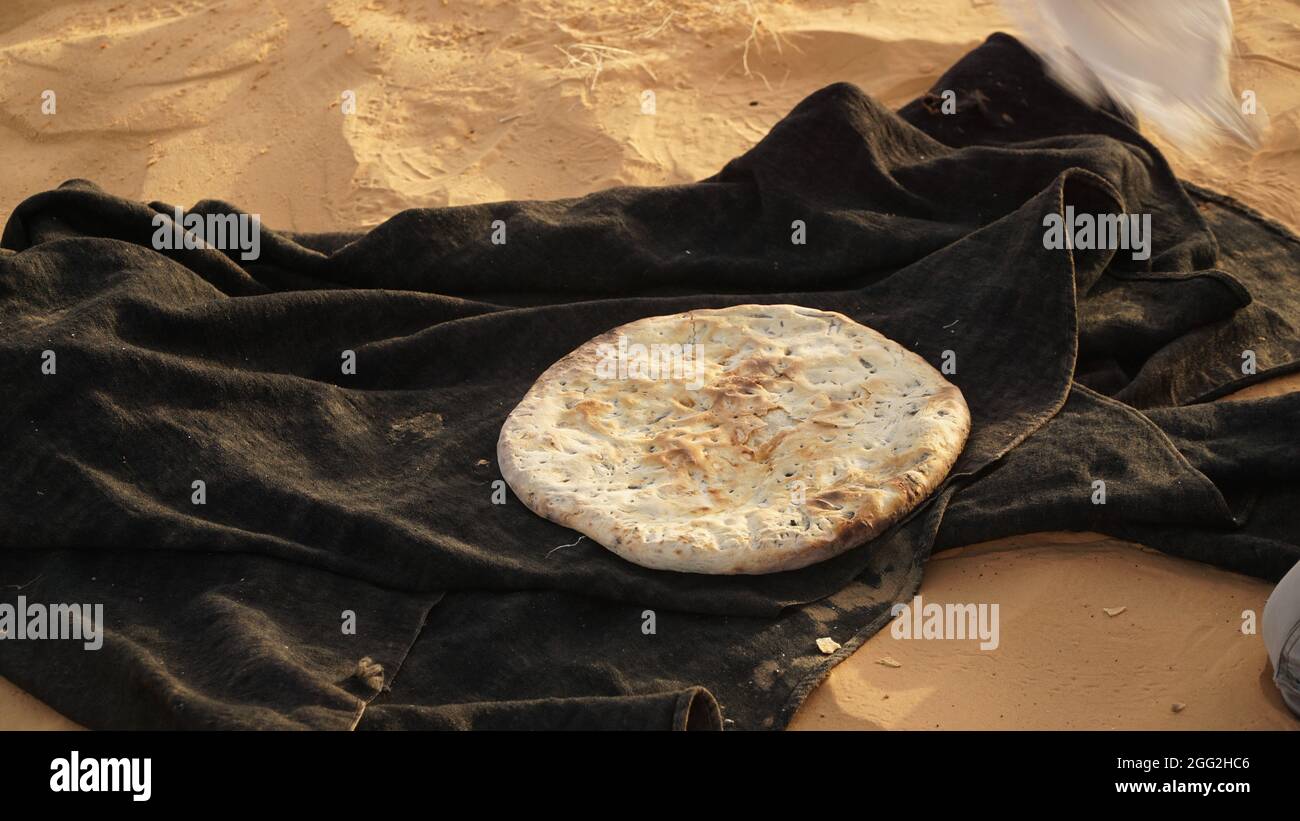 Sahara bread baking in the ground in the desert landscape of the Sahara ...