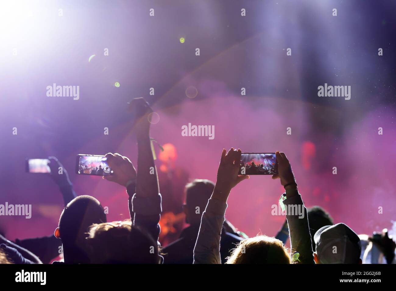 Crowd at concert - Cheering crowd in bright colorful stage lights Stock ...