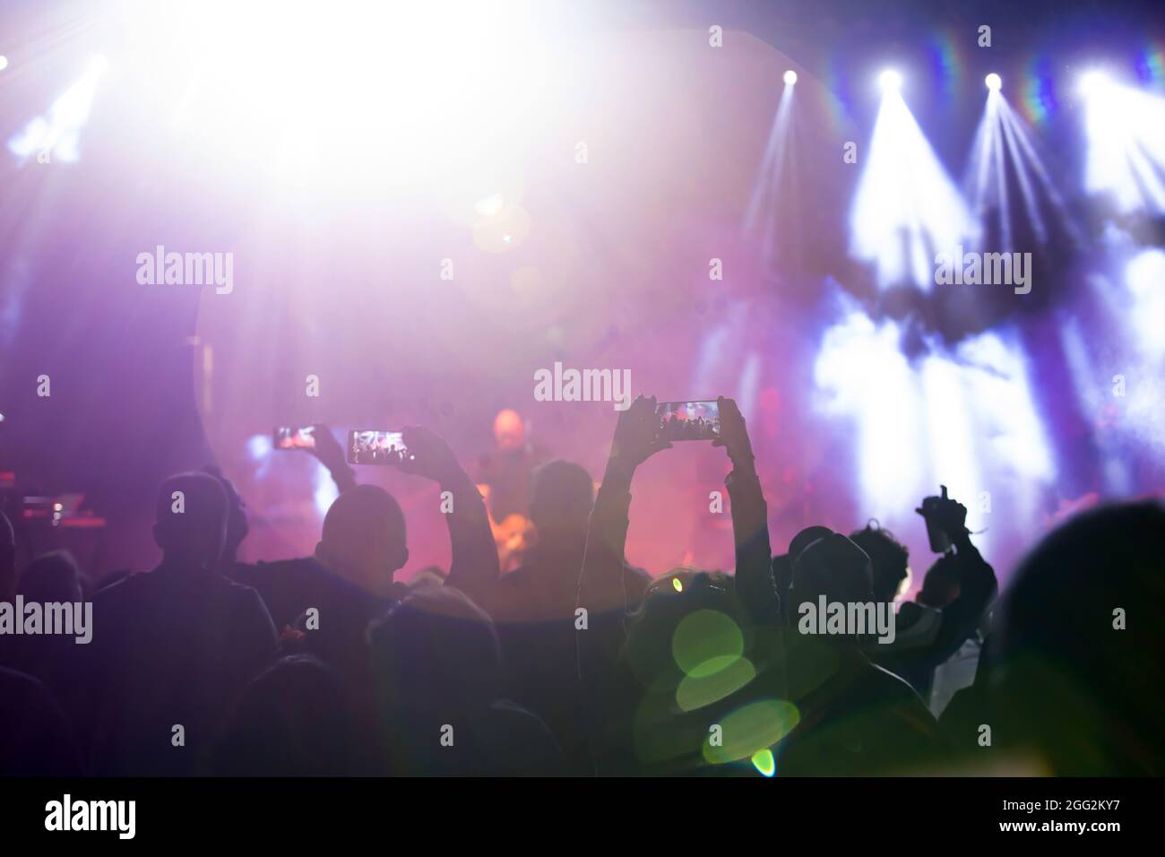 Crowd at concert - Cheering crowd in bright colorful stage lights Stock ...