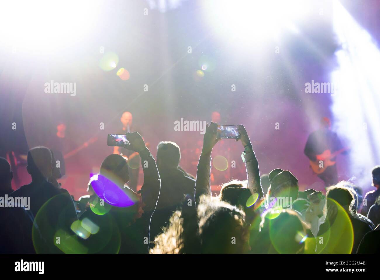 Crowd at concert - Cheering crowd in bright colorful stage lights Stock ...