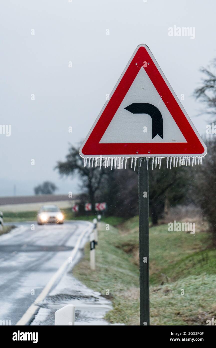 Sign showing the direction and the road with a car driving along it ...