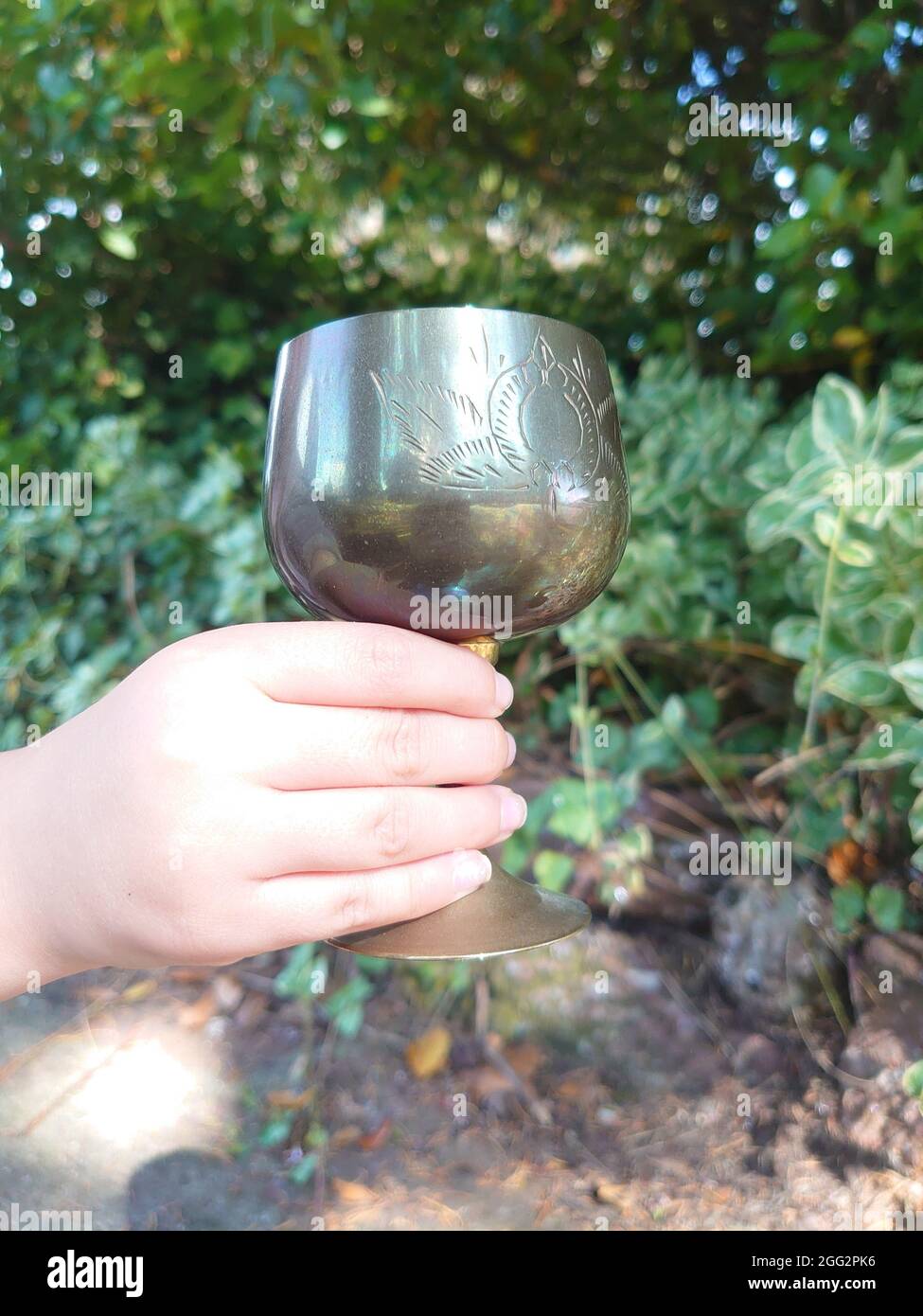 Selective focus of female hand holding a vintage brass goblet Stock ...