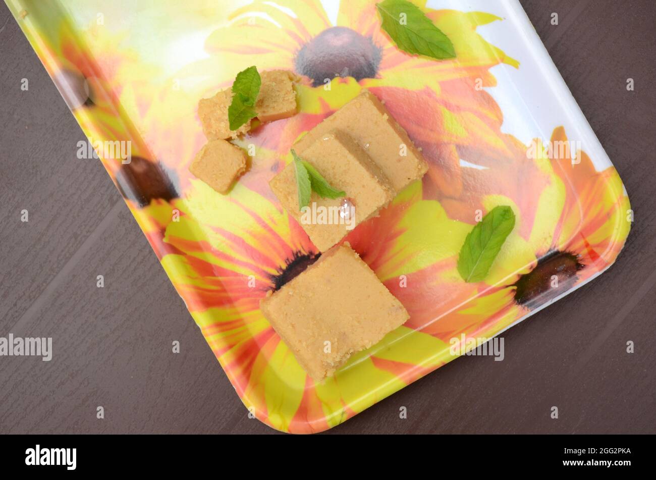 Top view shot of a brown color condensed milk sweet with green mint ...