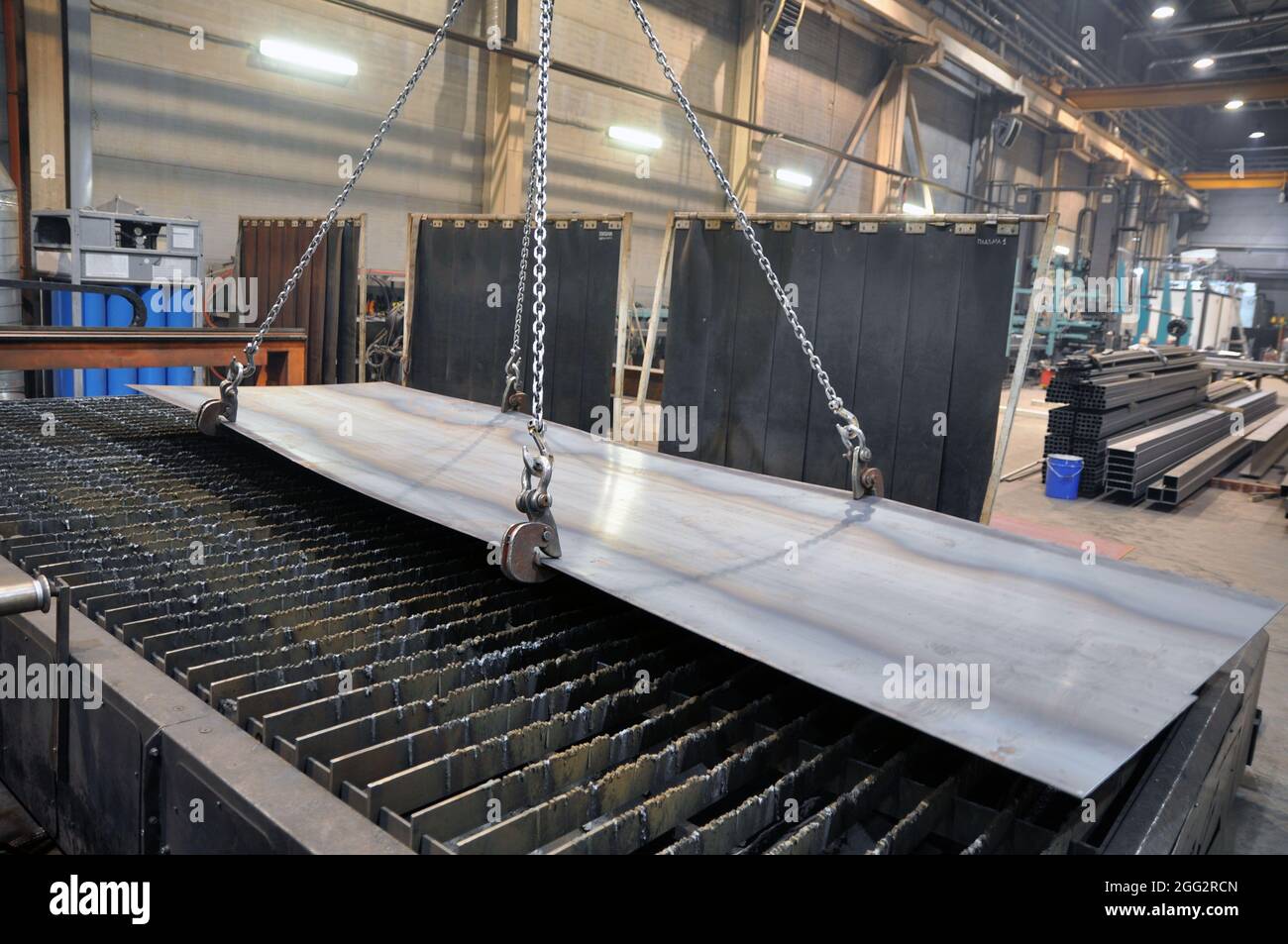 Lifting chains and hooks for loading sheet metal. Placing metal on a ...