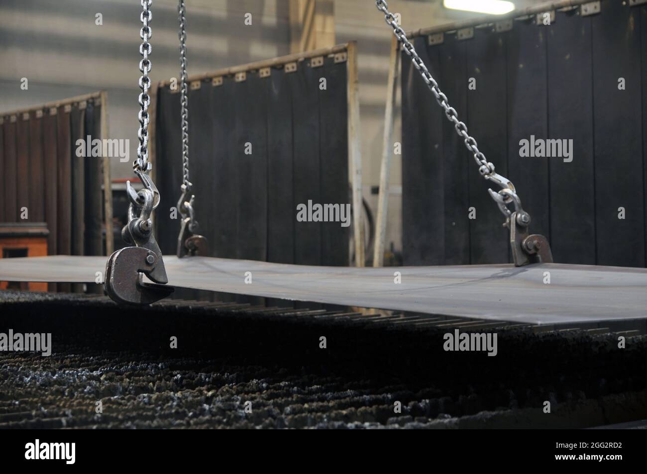 Lifting chains and hooks for loading sheet metal. Placing metal on a ...