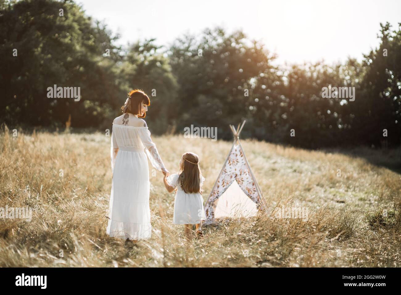 Back rear view of stunning mother and little daughter dressed in native ...