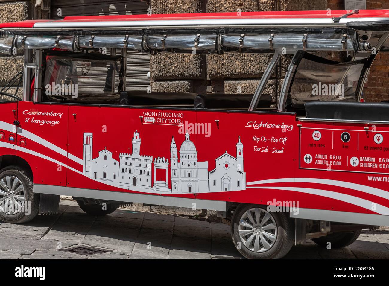 Narrow alley street with tour guide bus group in small town ...