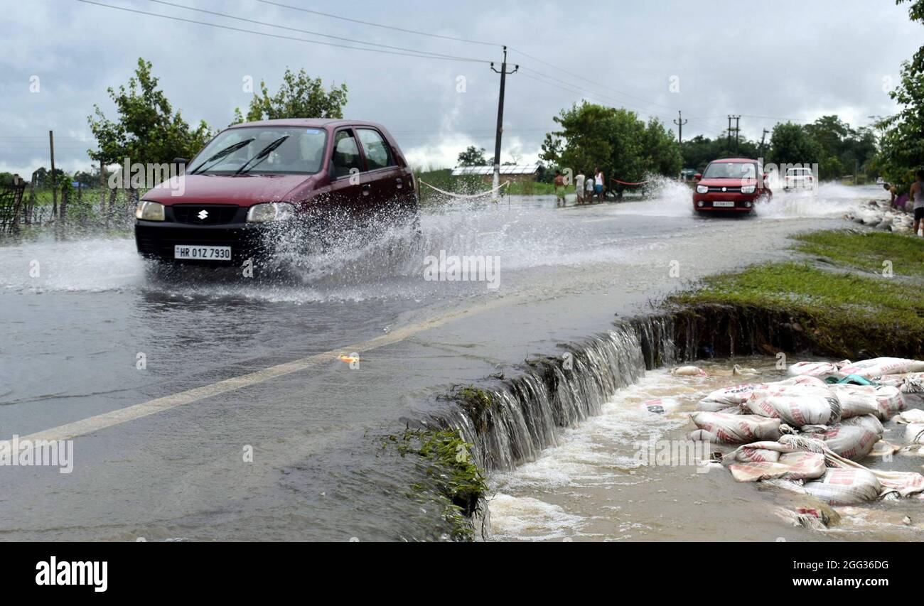 (210828) -- DHEMAJI, Aug. 28, 2021 (Xinhua) -- Vehicles cross a flooded ...