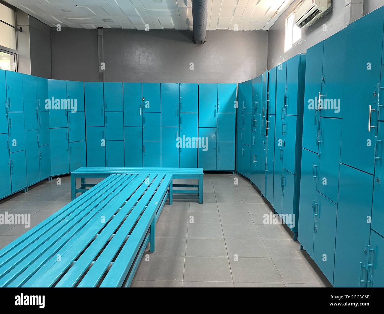 Empty dressing room with blue lockers and blue benches Stock Photo - Alamy