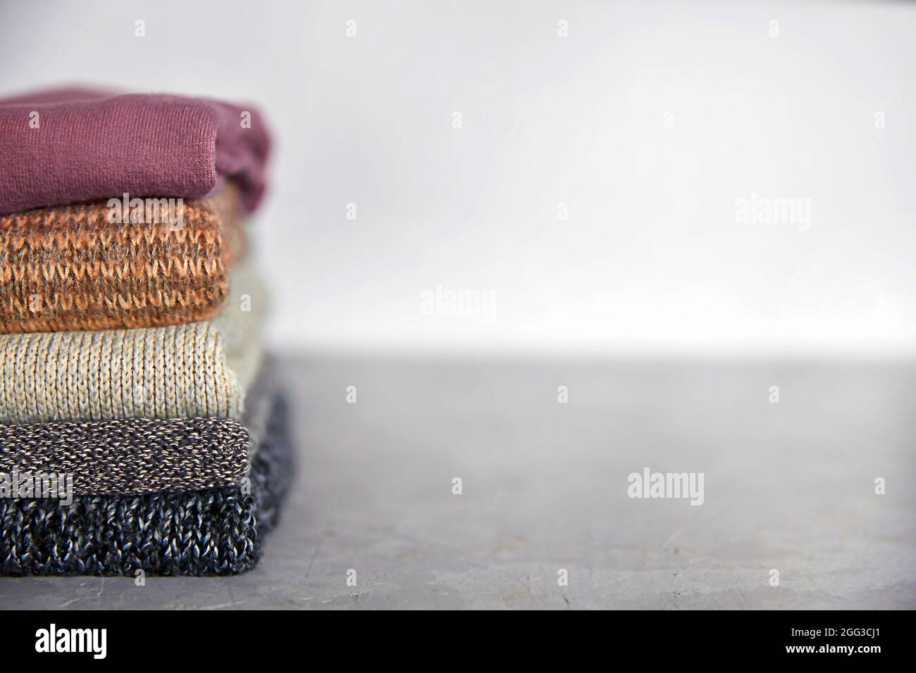 Winter warm woolen sweaters on gray wooden retro desk.White window sill ...