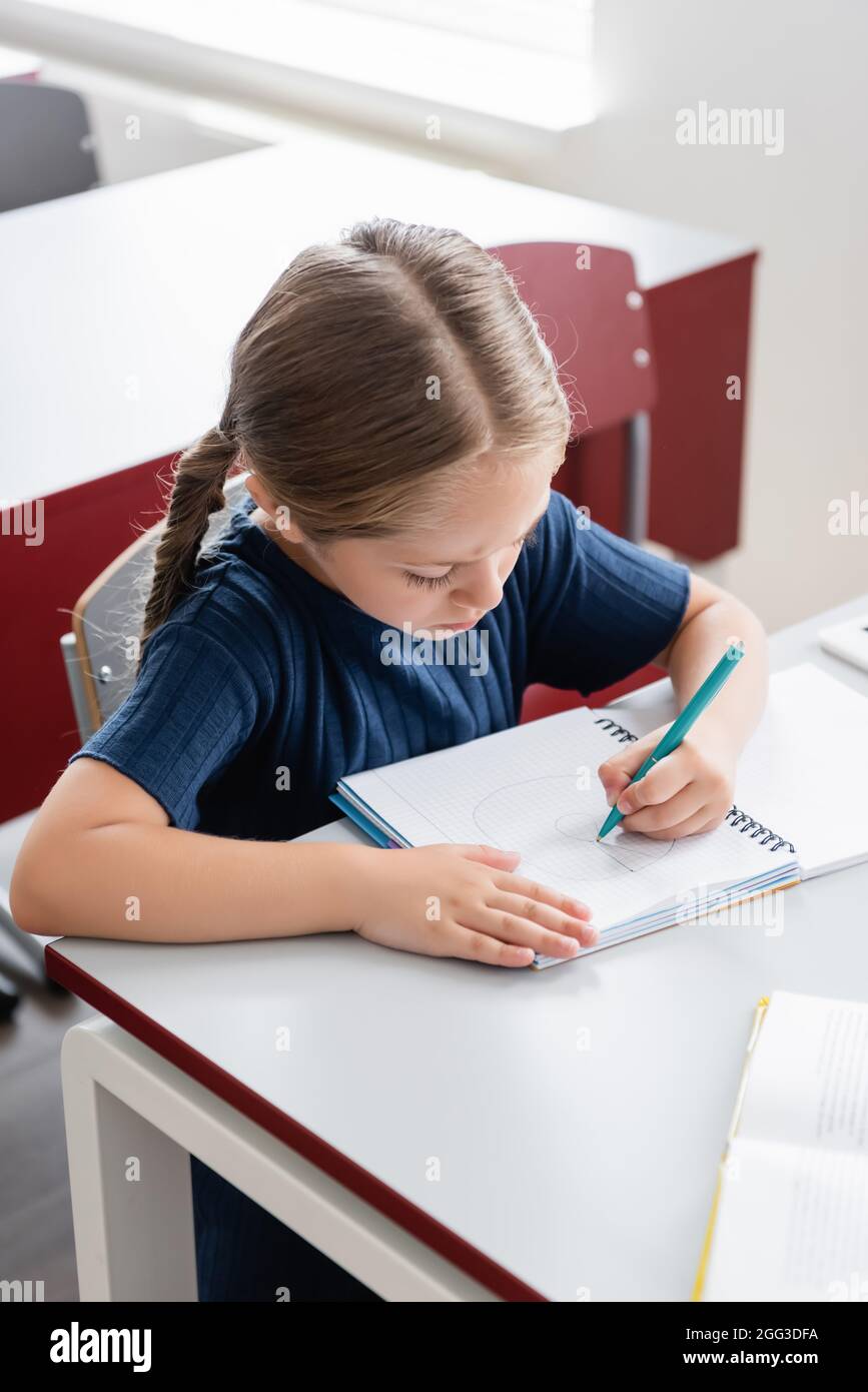 schoolgirl writing in notebook during lesson at school Stock Photo - Alamy