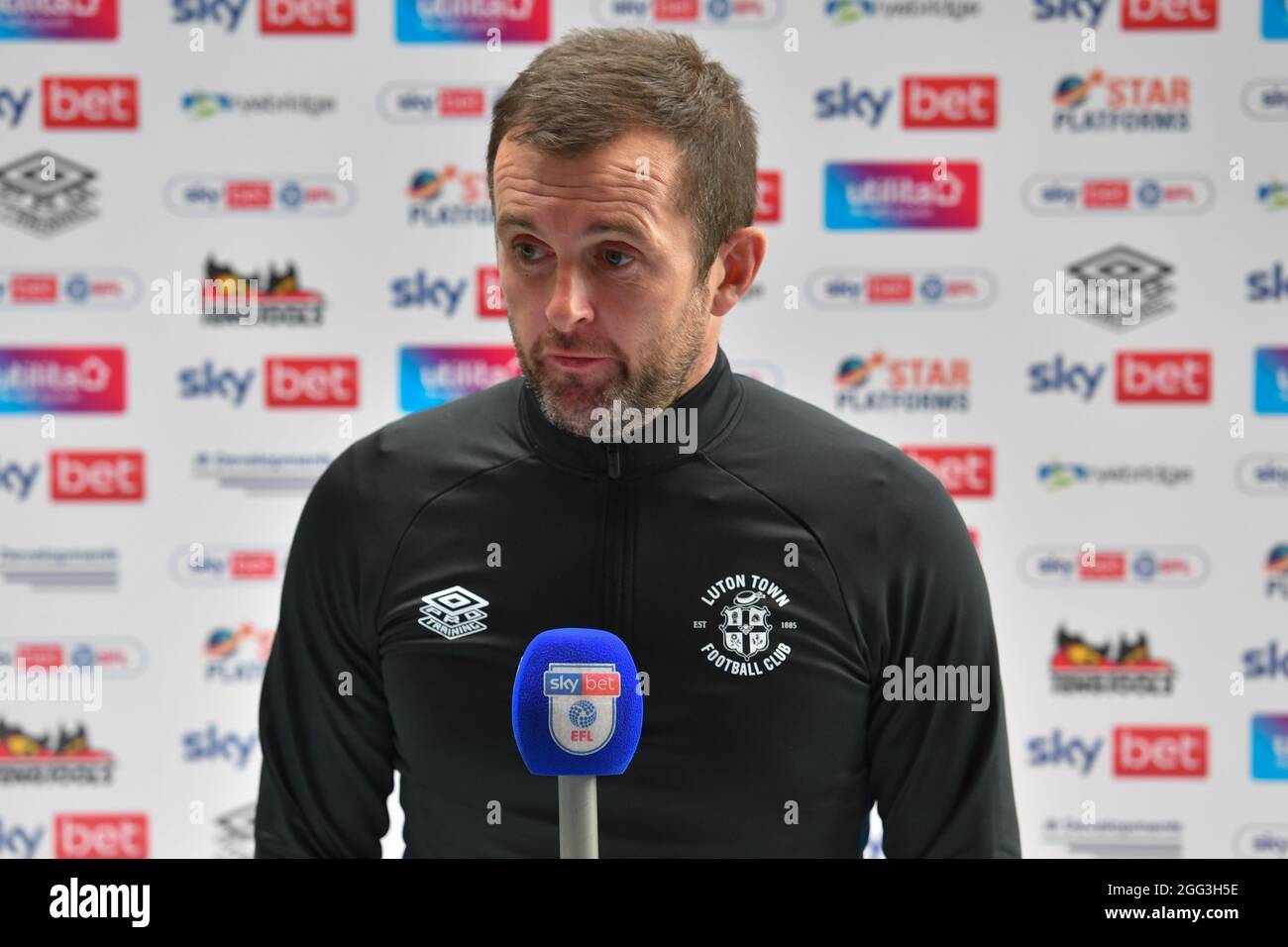Luton, UK. 28th Aug, 2021. Nathan Jones manager of Luton Town talks to ...