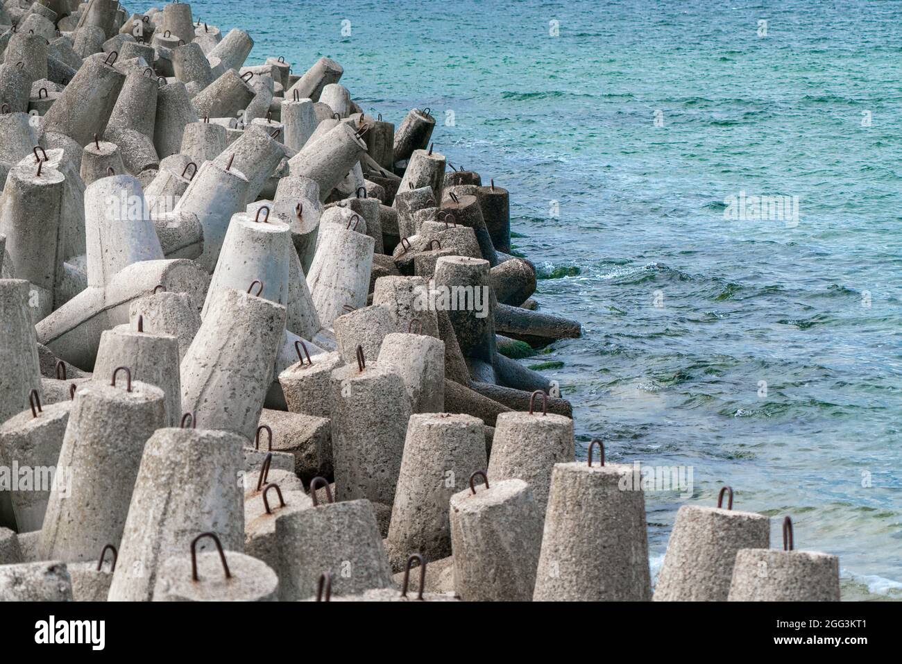 Detail shot of concrete tetrapod dolosse breakwater with steel eyes ...
