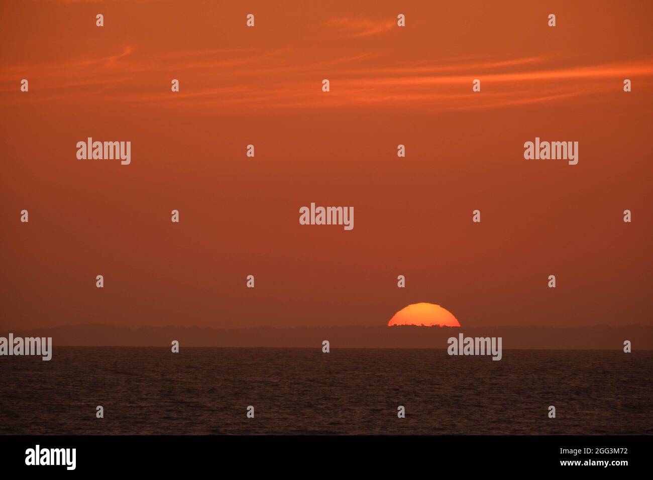 A setting sun photographed during August 2021, from the Gower Peninsula ...