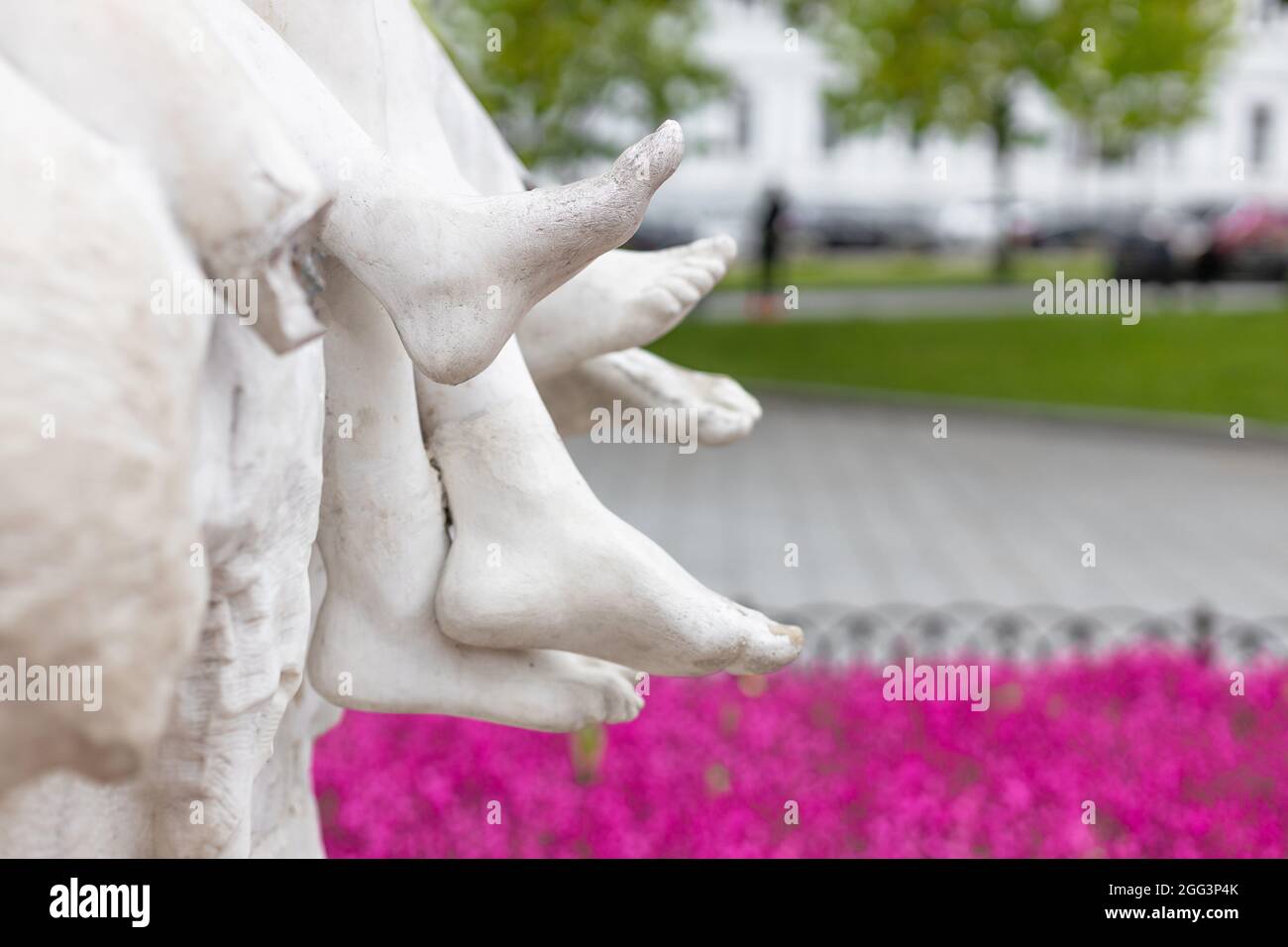 Detail of white stone statue foot in the city park in summer Stock ...