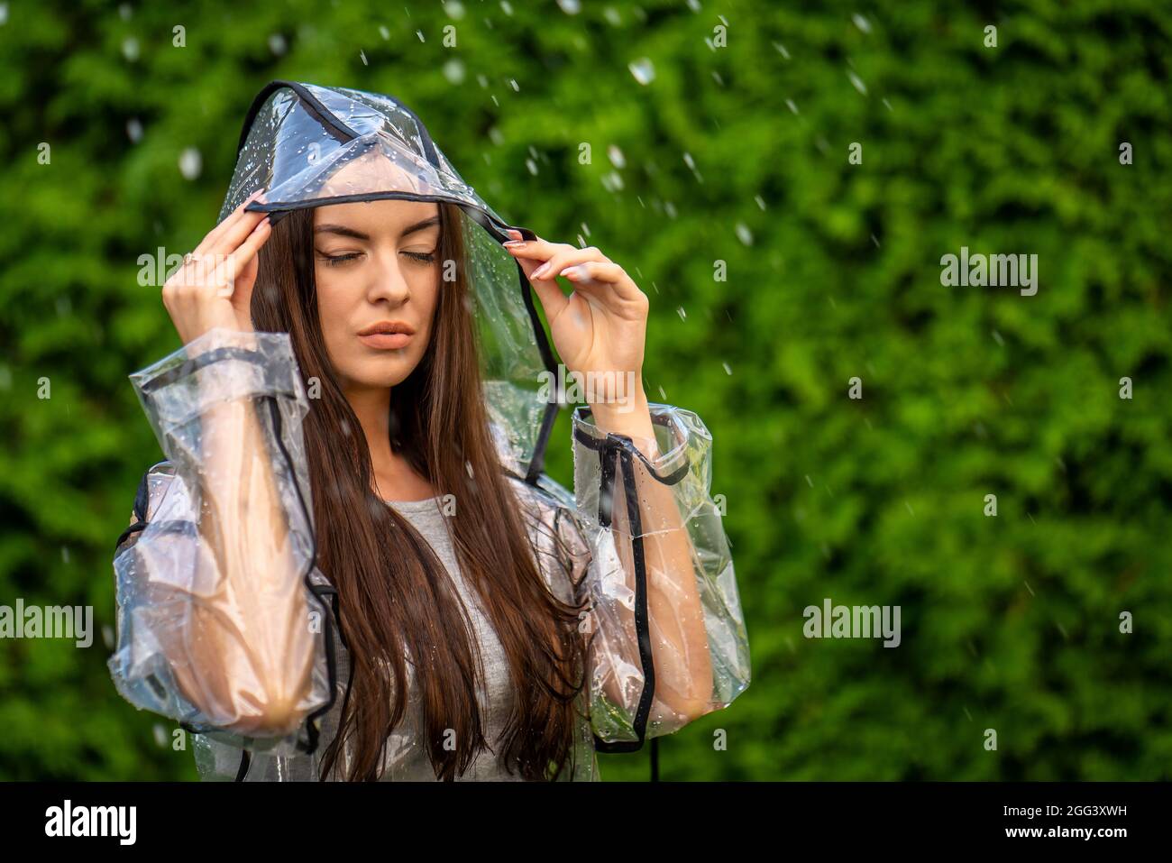 Young beautiful woman in hooded raincoat on rainy day Stock Photo - Alamy