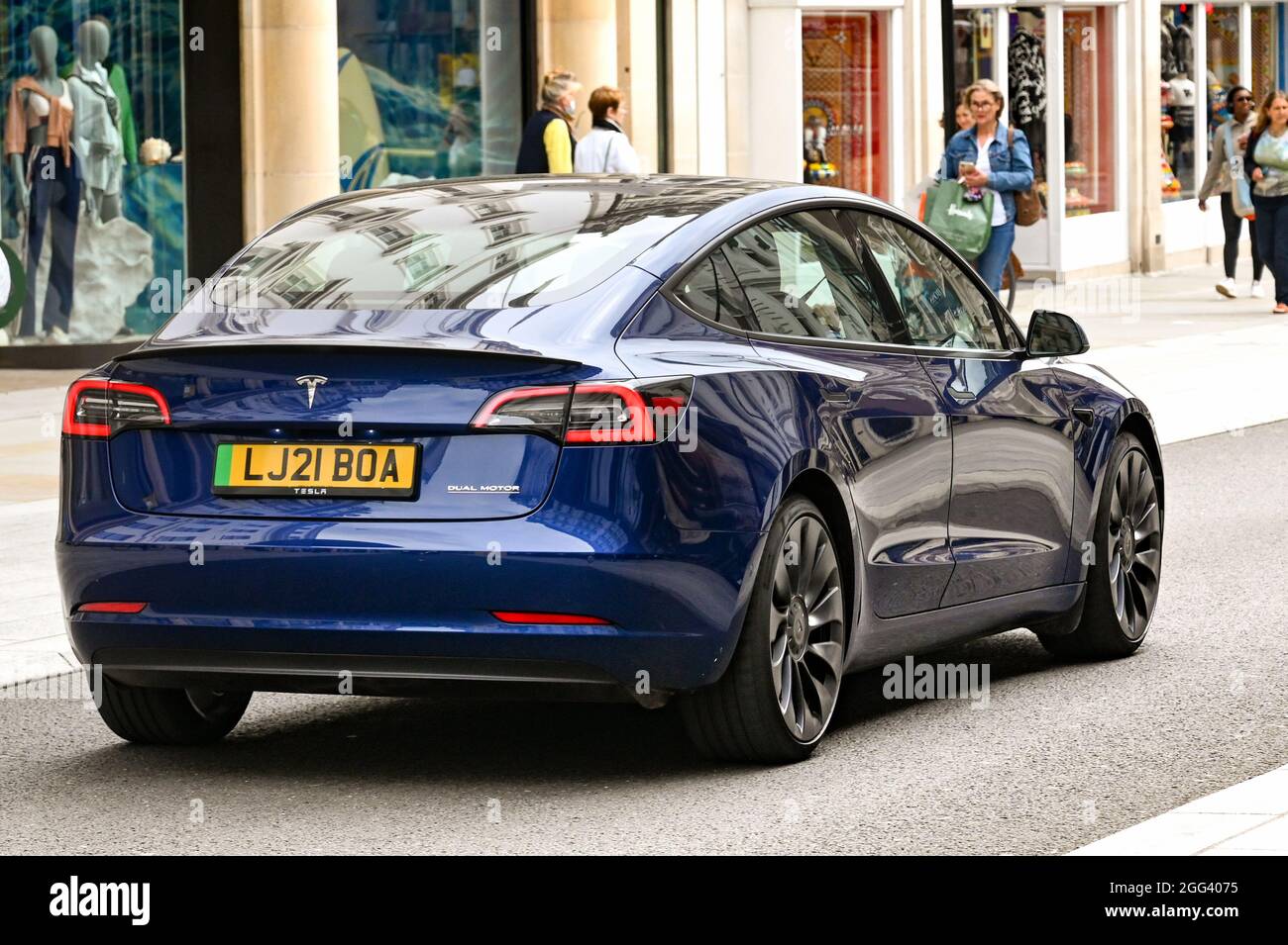 London, England - August 2021: Tesla electric car driving past shops on ...