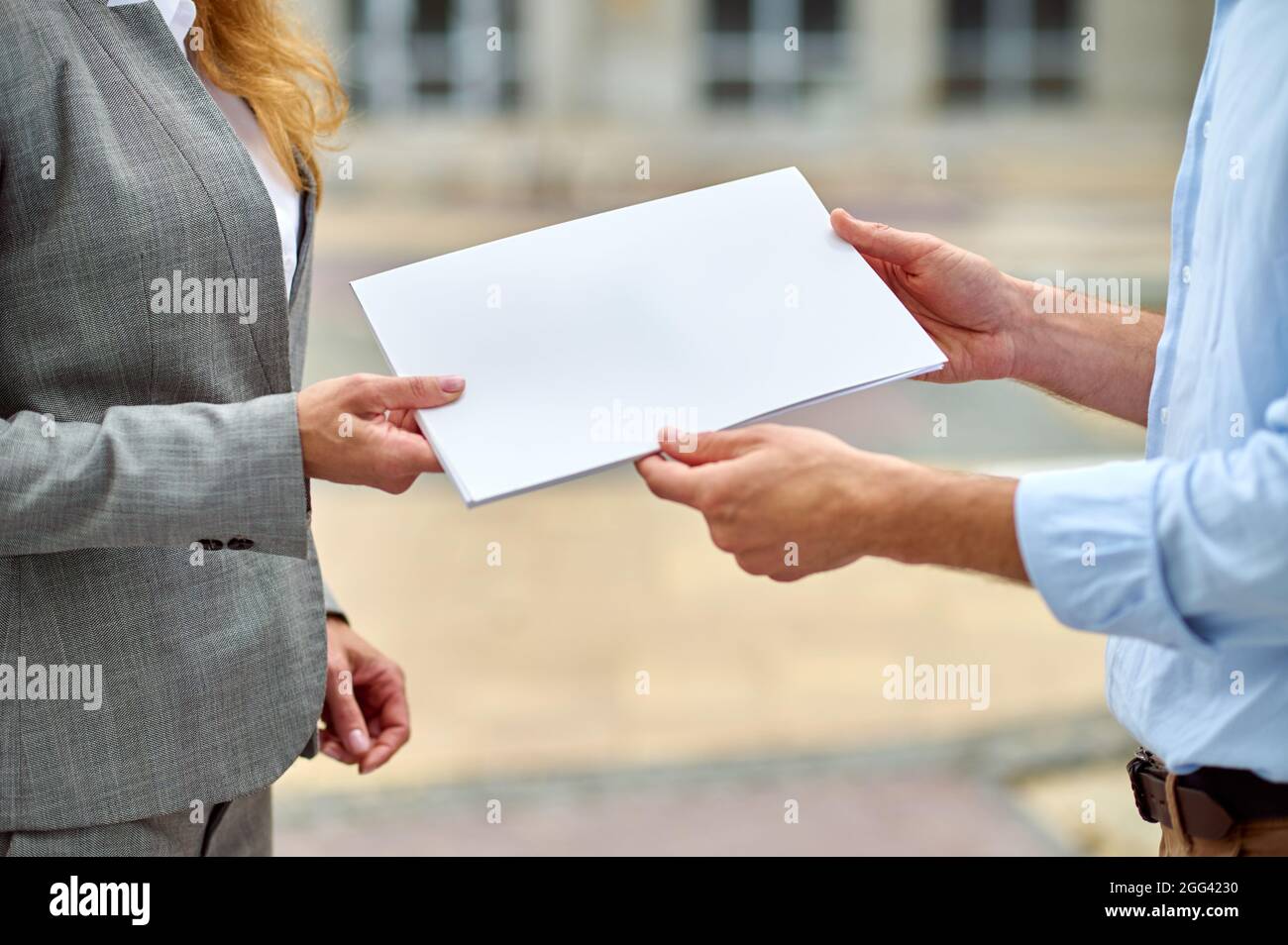 Supervisor returning a folder with documents to a construction engineer ...