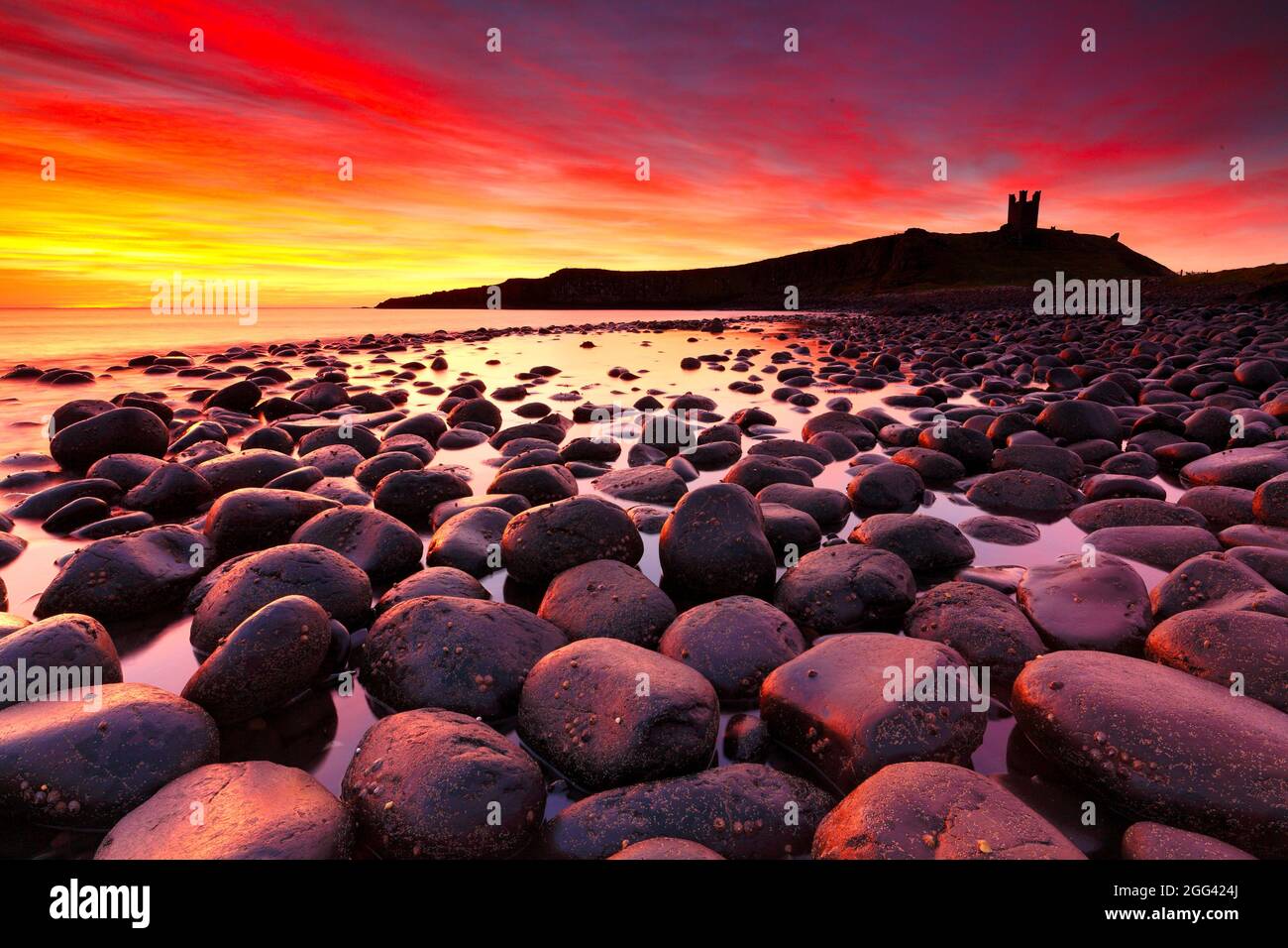 Sunrise at Embleton Beach with Dunstanburgh Castle in the background ...
