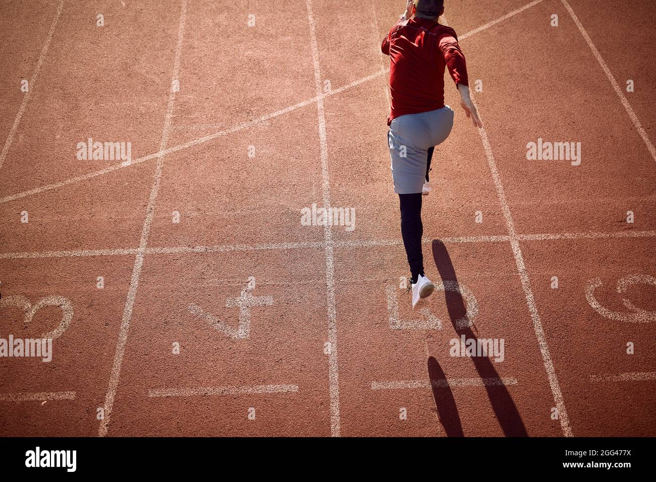 Sprinter taking off from starting block on running track.Sports concept ...
