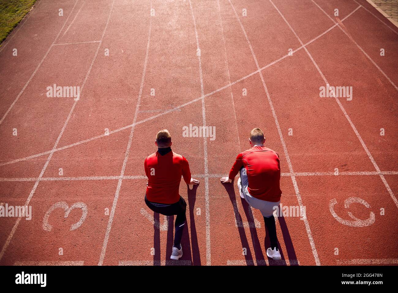 athletes men in sport clothes run at the running track in professional ...