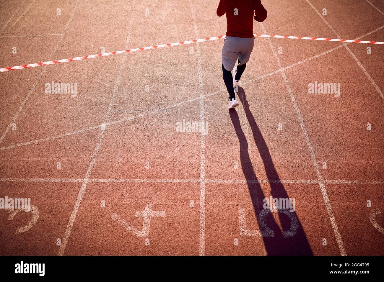 Winning young male Athlete crosses the finish line Stock Photo - Alamy