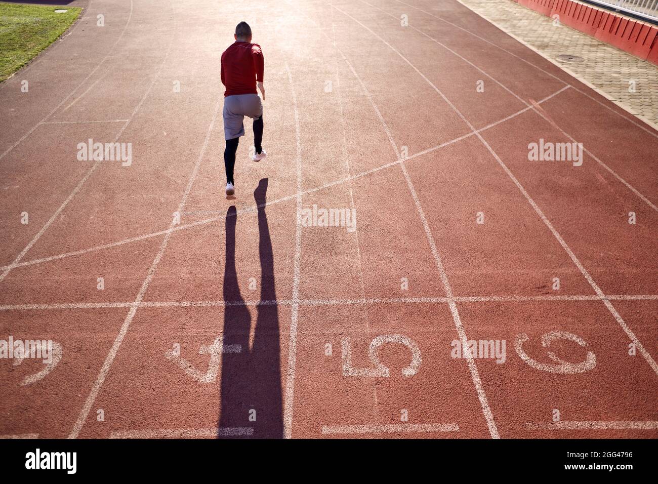 Male athletes sprinting. man in sport clothes run at the running track ...