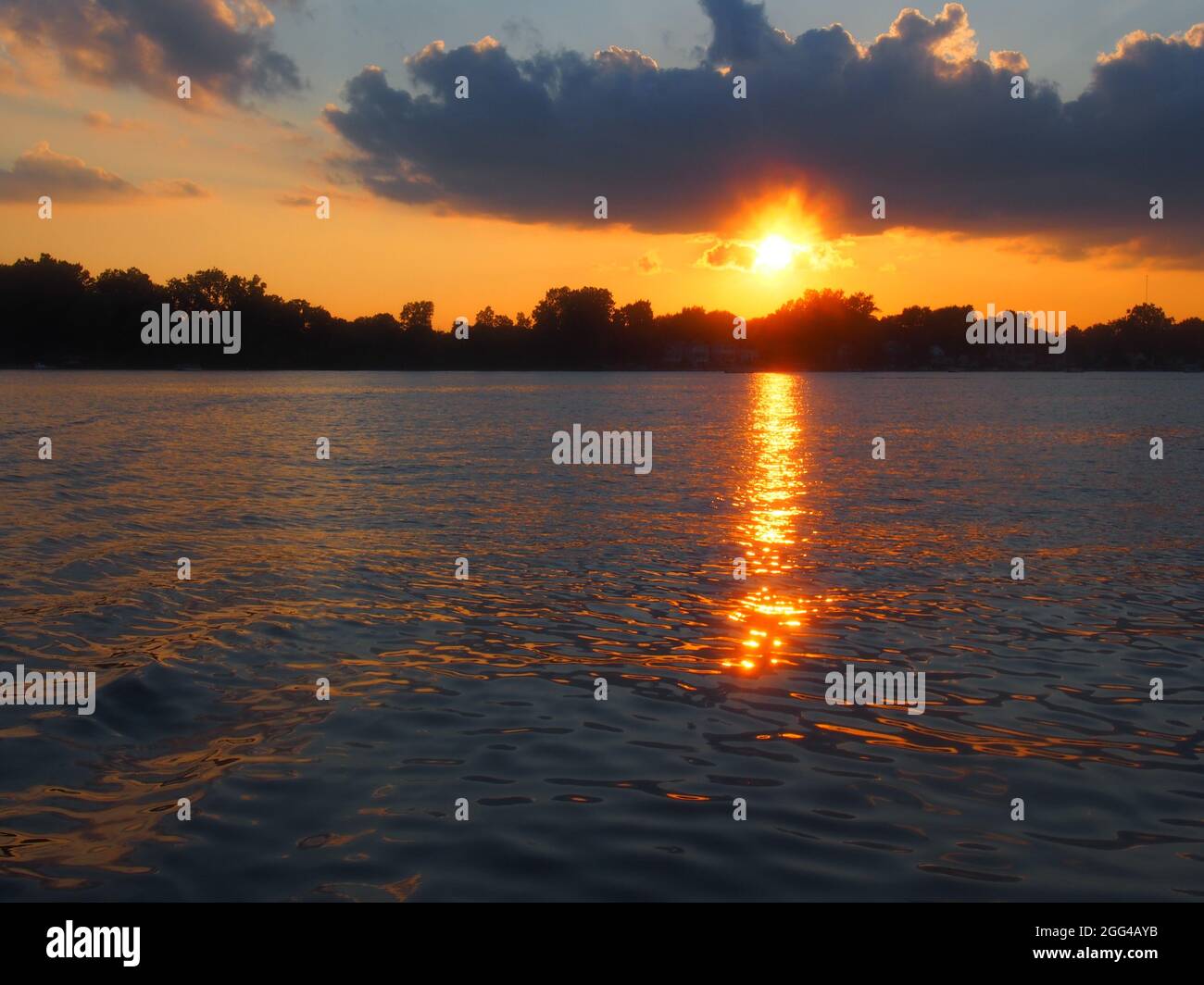 Brightly Lit Lake Sunset with Orange Reflections Stock Photo - Alamy