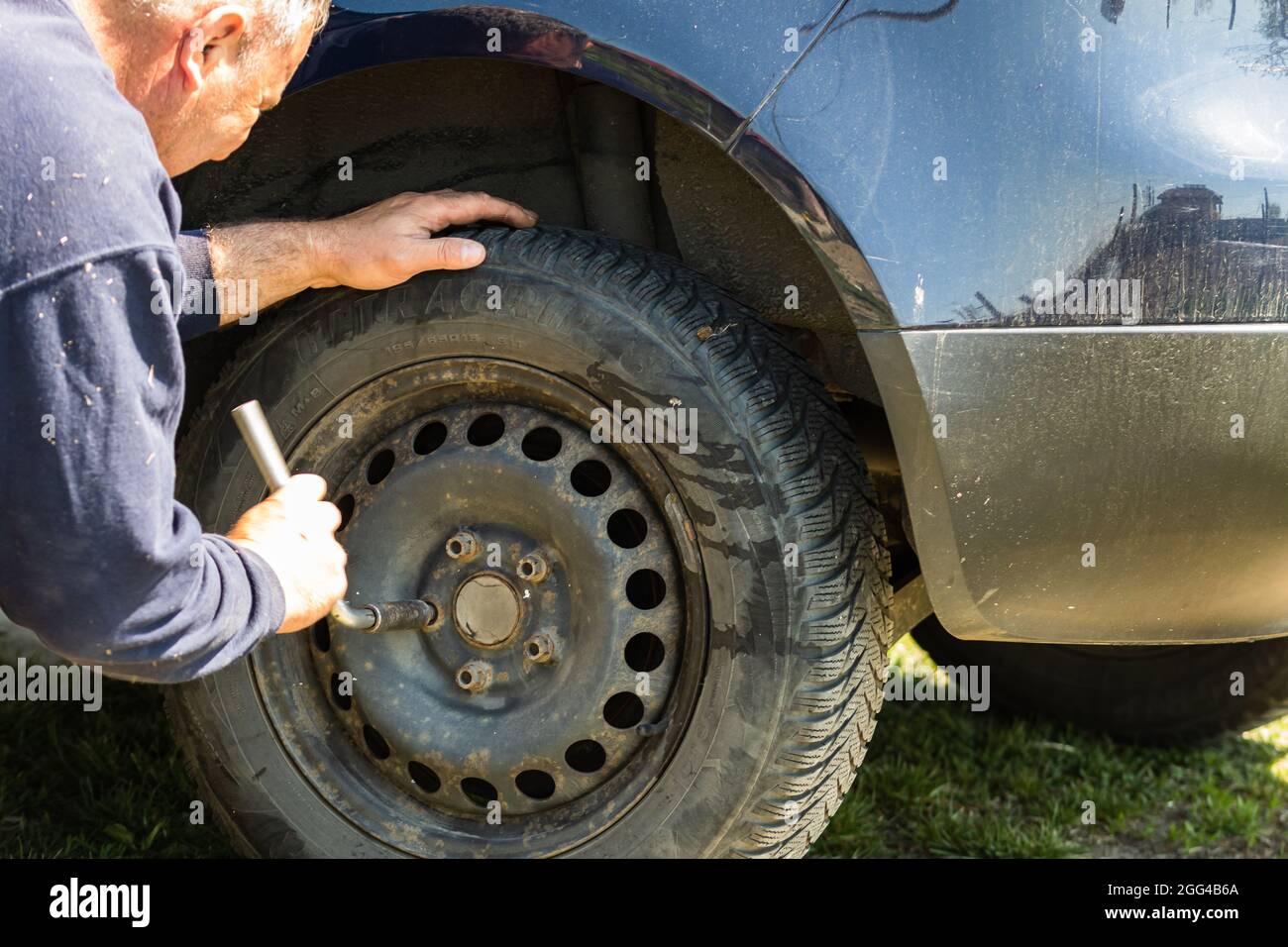 Car mechanic screwing or unscrewing car wheel by wrench at car garage ...