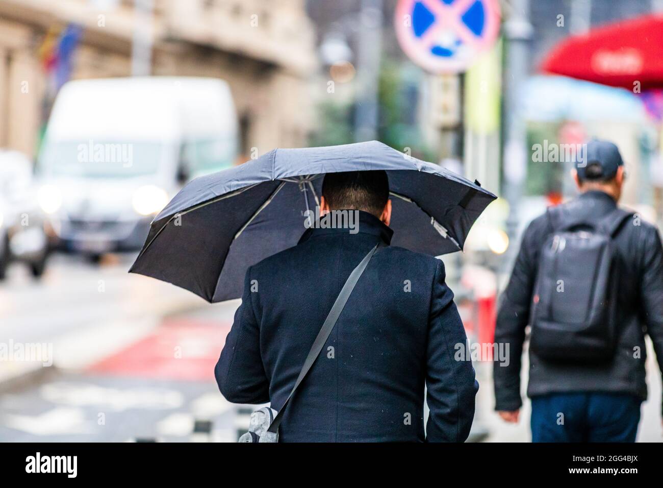 People with umbrella on the street on a rainy day in Bucharest, Romania ...