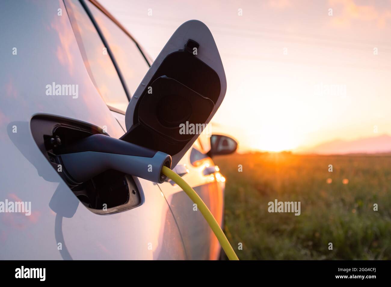 Close up shot of an opened electric car charging socket cap and charger ...