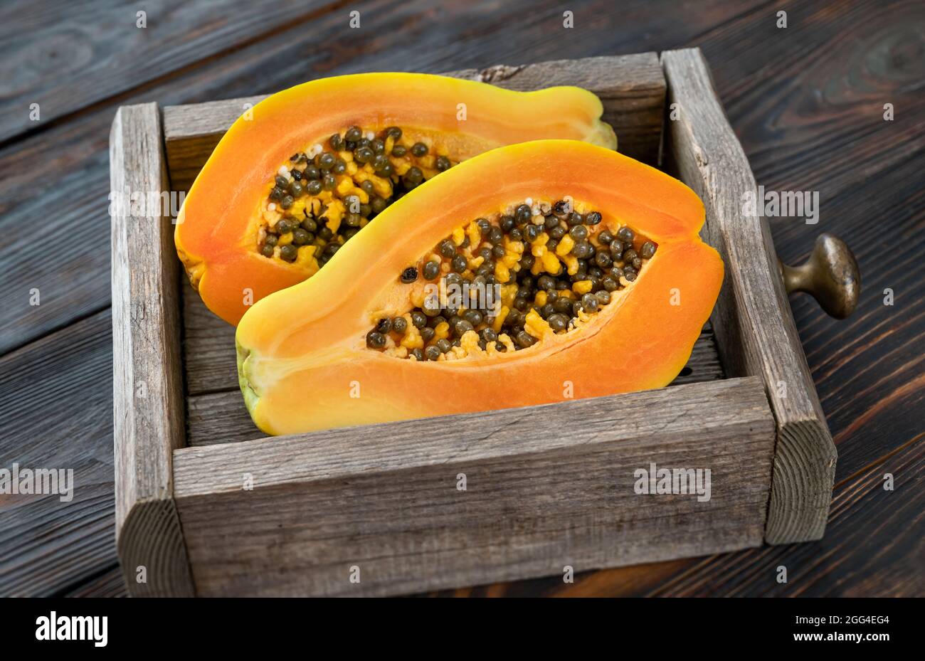 Papaya in the wooden box: cross section Stock Photo - Alamy