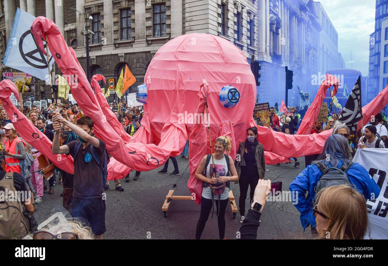 London, UK. 28th Aug, 2021. Protesters carry a giant model octopus ...