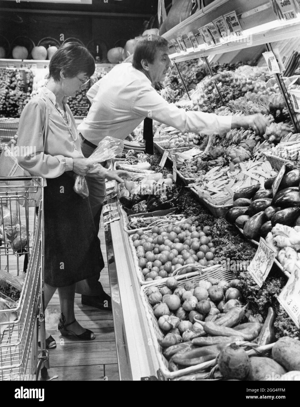 Austin Texas USA, circa 1989: Male and female shoppers select produce ...